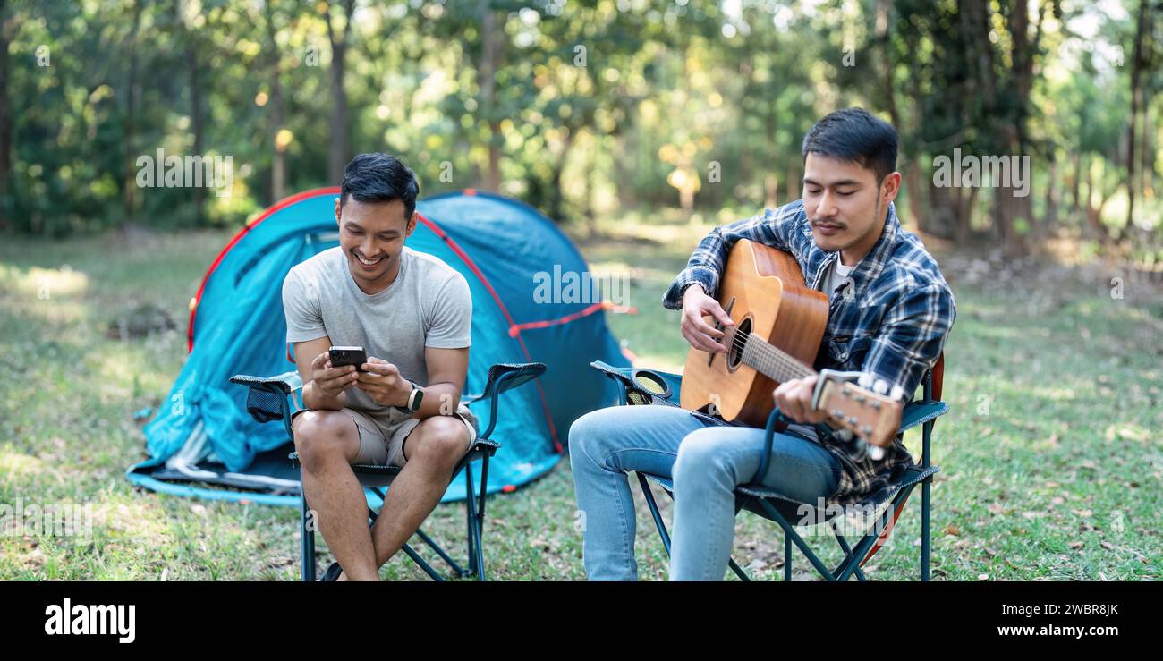 LGBTQIA Gay couple camping together in woods for holidays and relax on ...
