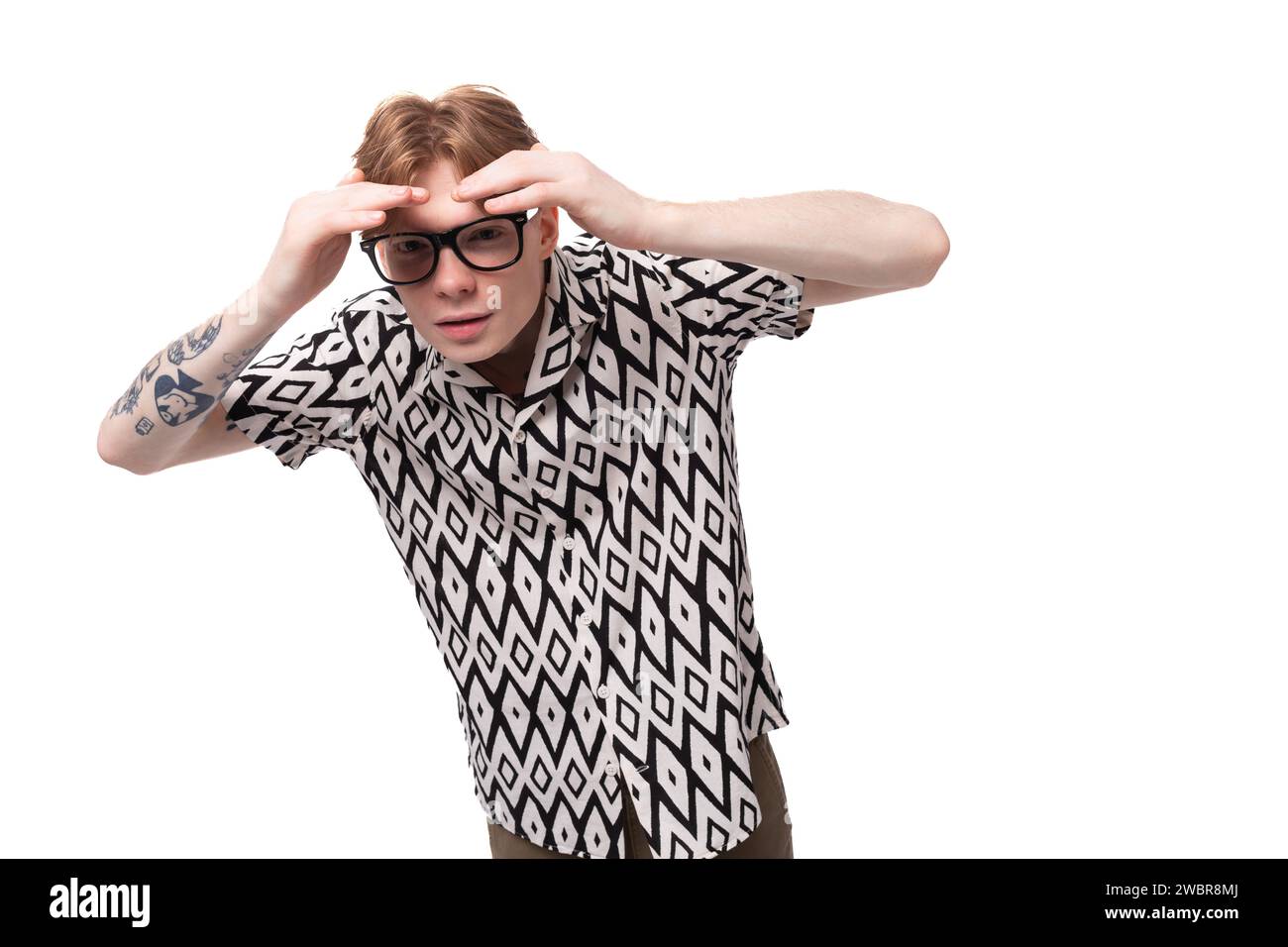 a young caucasian guy with red hair dressed in a shirt squints because ...