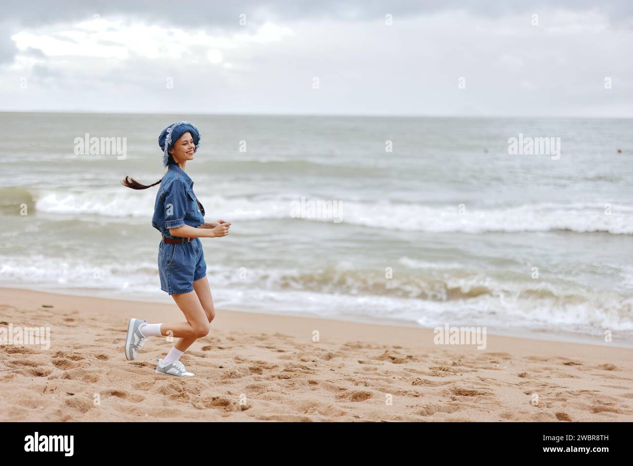 Sea Breeze: A Stylish Young Woman Enjoying a Romantic Sunset Walk on ...