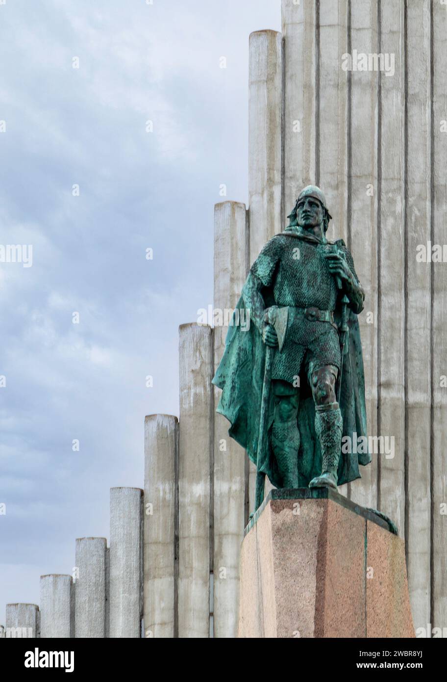 Low angle of aged stone statue of Norse explorer with Hallgrimskirkja ...
