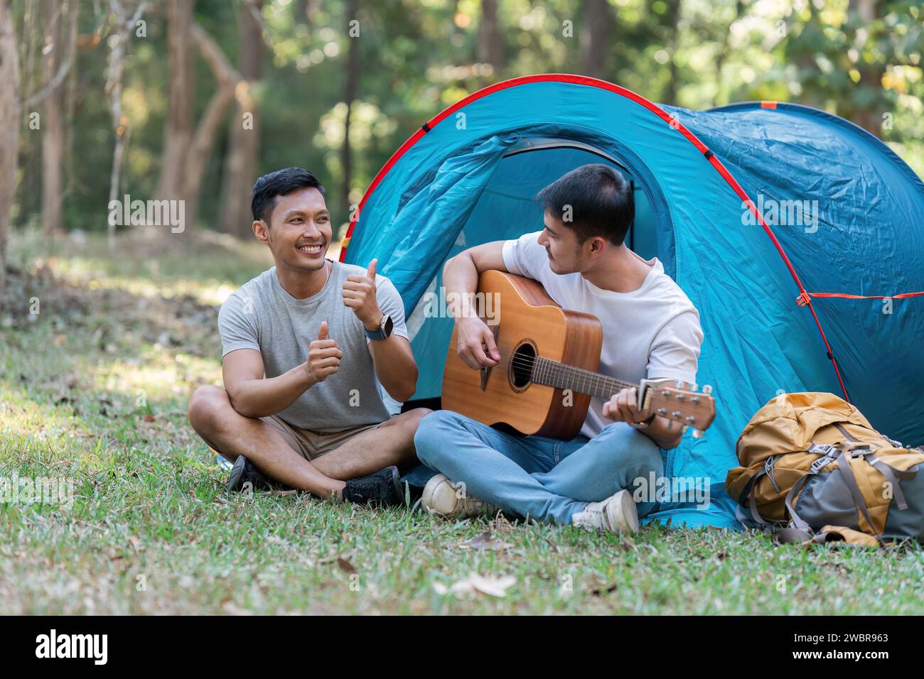 LGBTQIA Gay couple camping together in woods for holidays and relax on ...