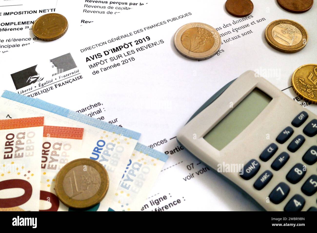 A calculator and some euro coins and banknotes on the top of a French ...