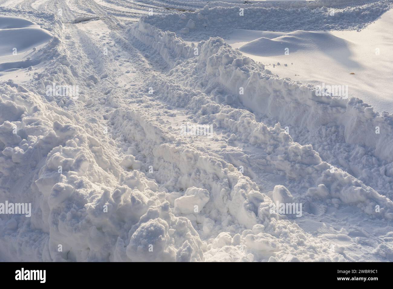 Uncleared road covered with snow with tractor marks Stock Photo - Alamy