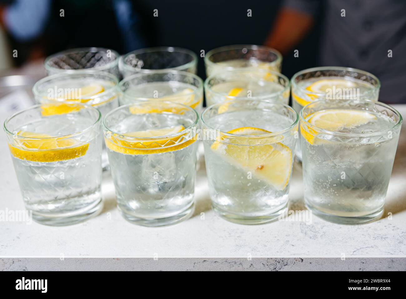 Multiple glasses of refreshing ice-cold lemon water garnished with ...