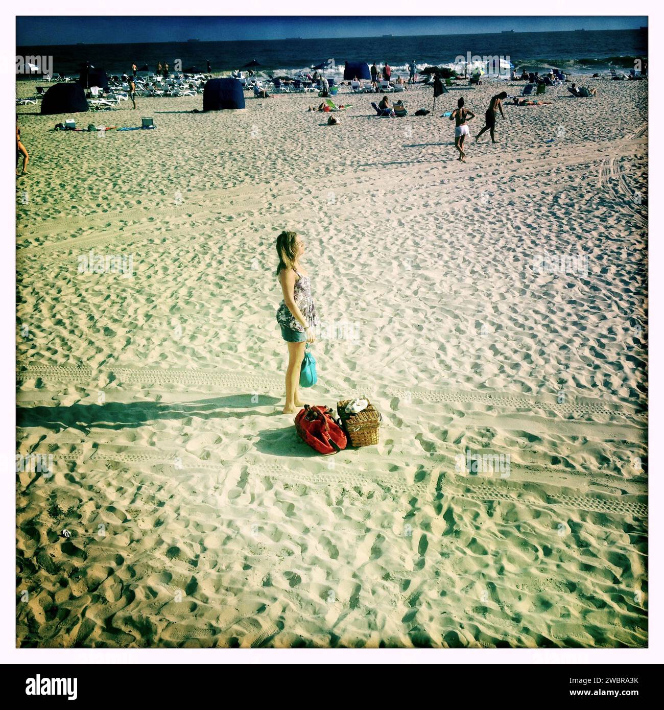 Woman catching final rays before leaving beach Stock Photo - Alamy