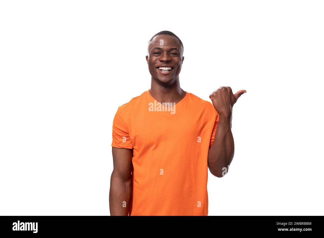 young inspired american man wearing orange mockup t-shirt holding index ...