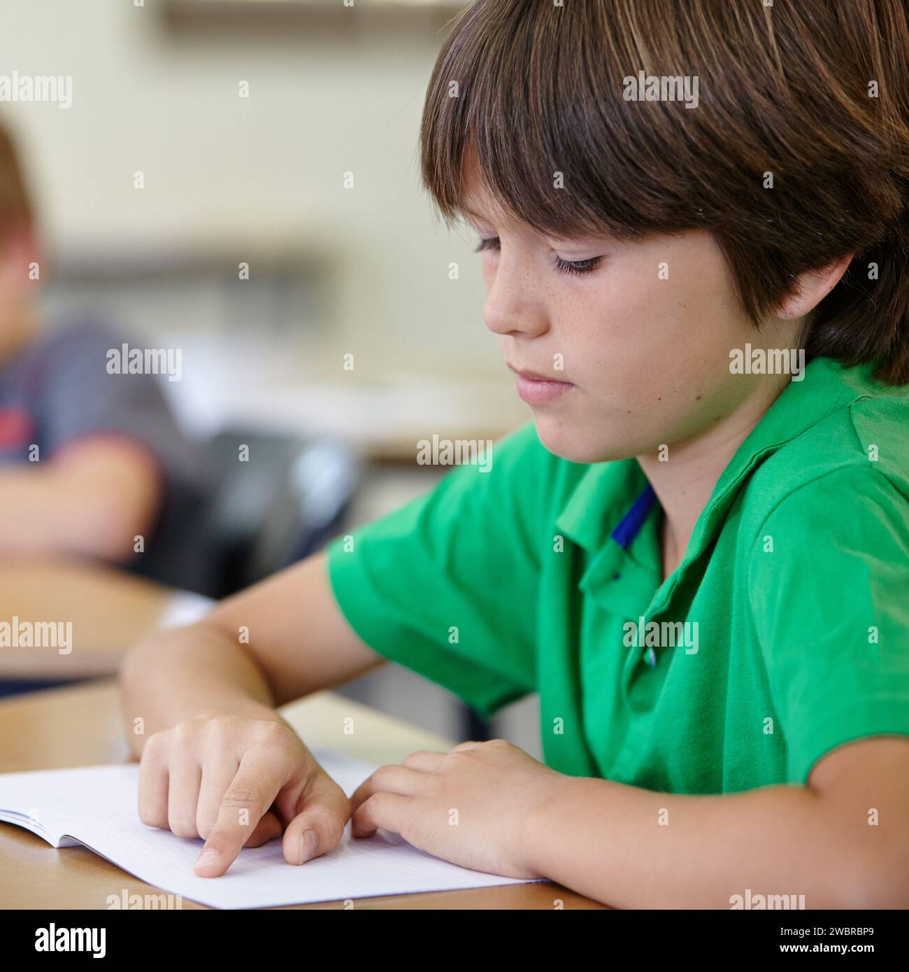 Classroom, notebook and child at desk, reading and education for ...