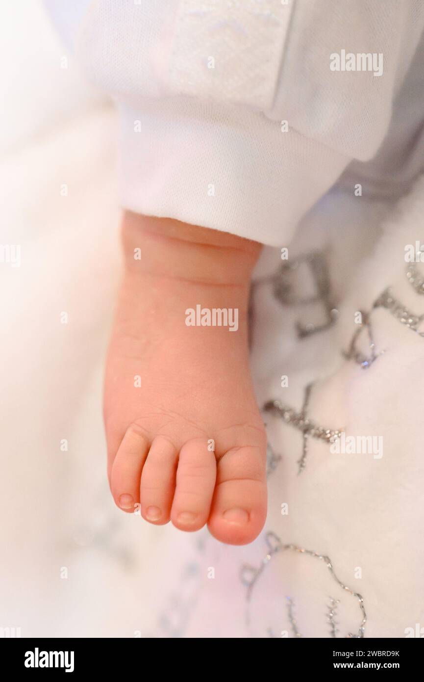 A baby's small leg during baptism on a white sheet Stock Photo - Alamy