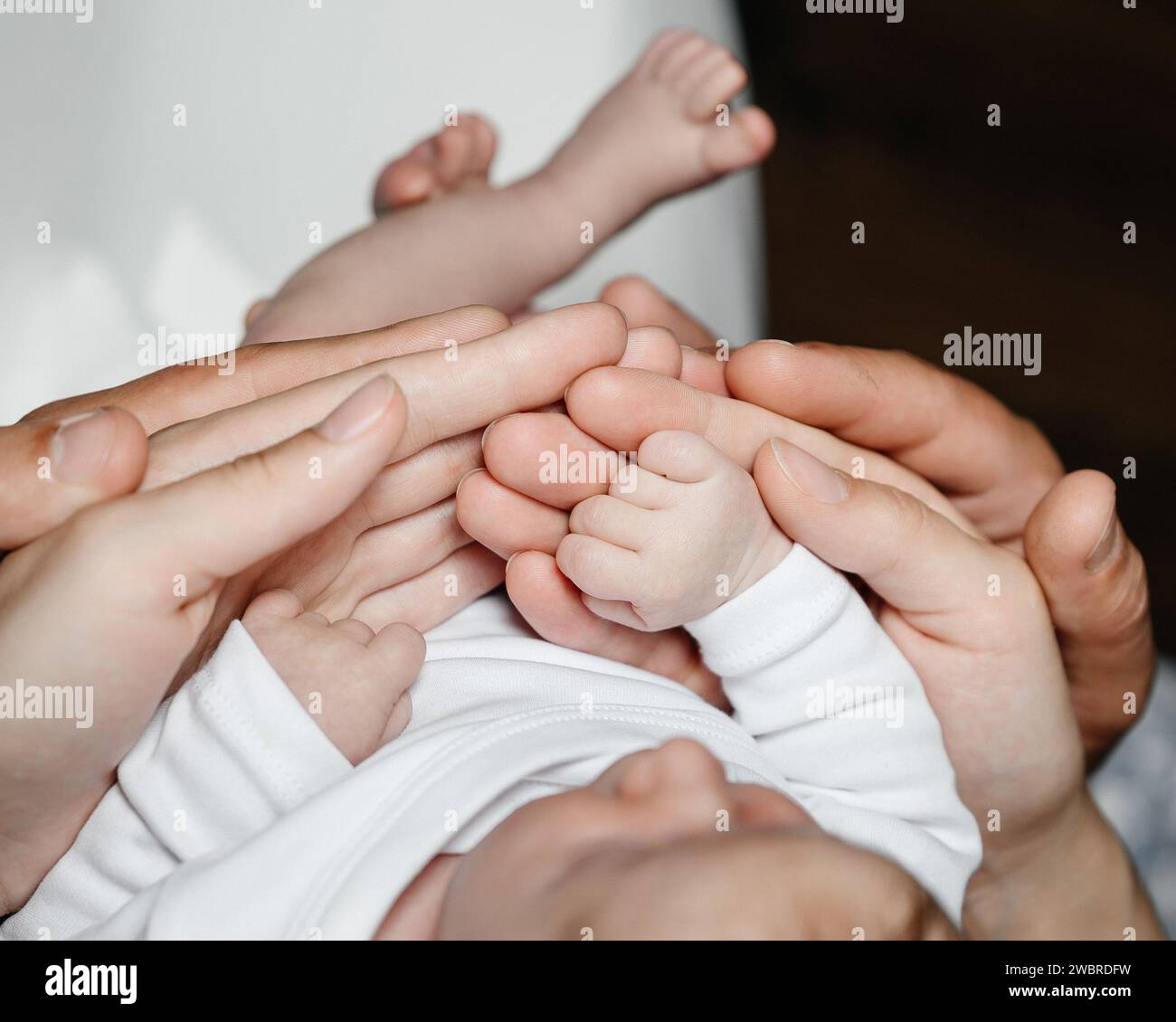 parents support a small newborn child with their hands Stock Photo - Alamy