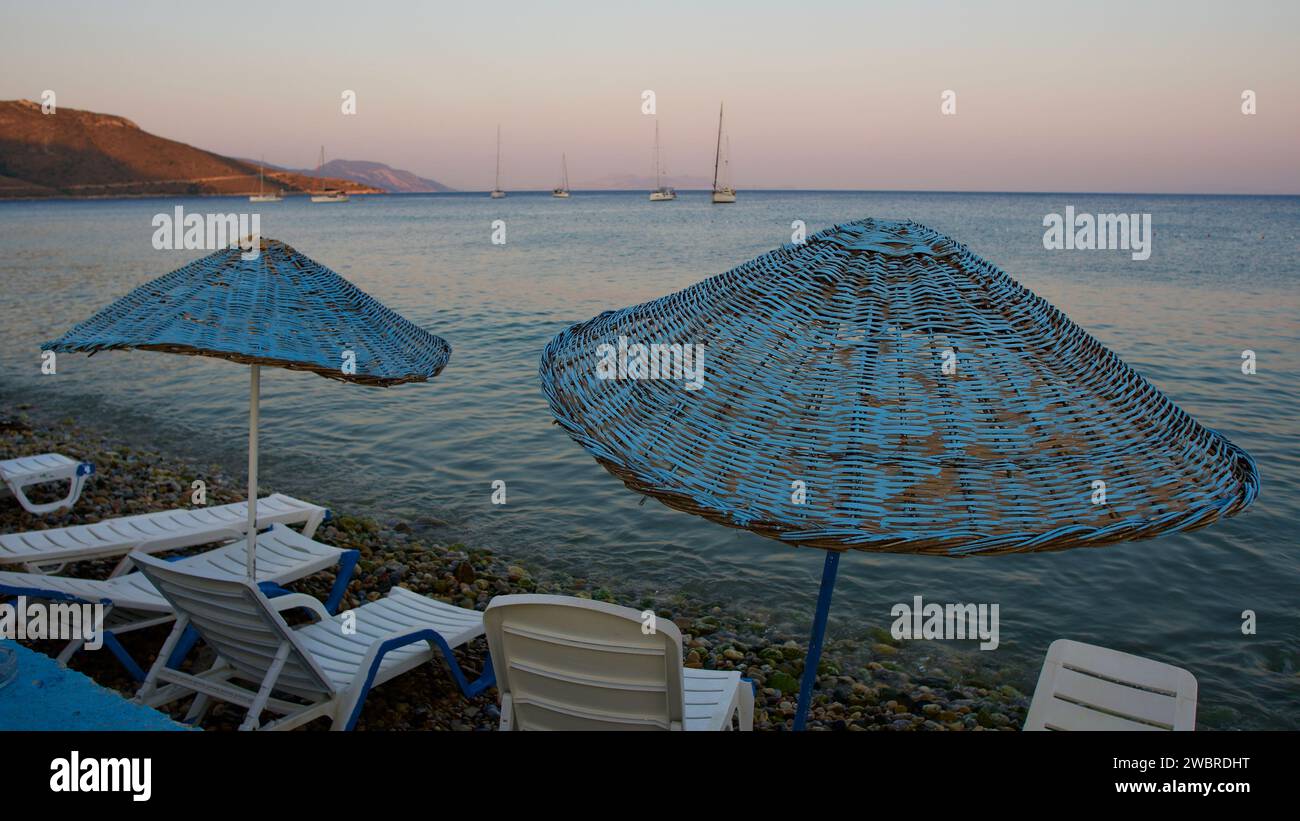Aegean and Mediterranean coasts at sunset. Wicker umbrellas and sun ...