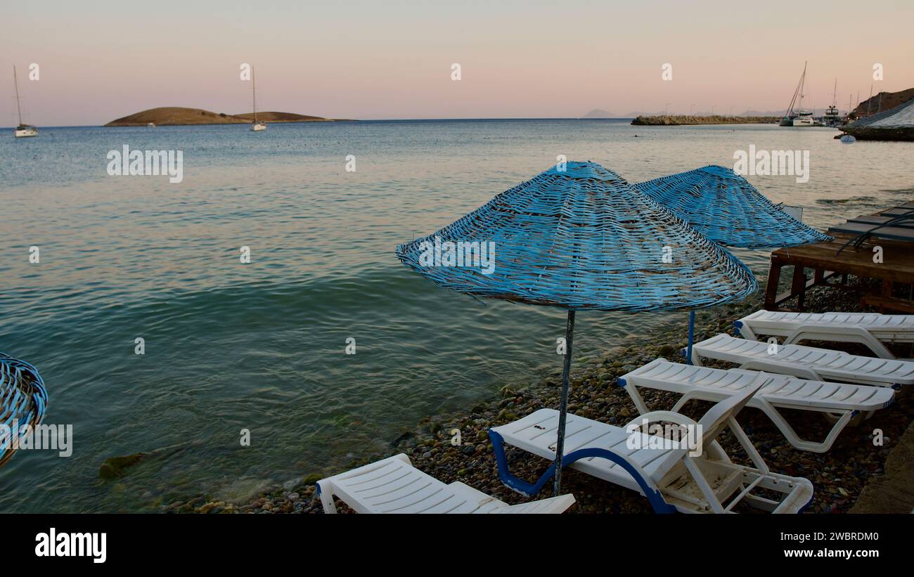 Aegean and Mediterranean coasts at sunset. Wicker umbrellas and sun ...