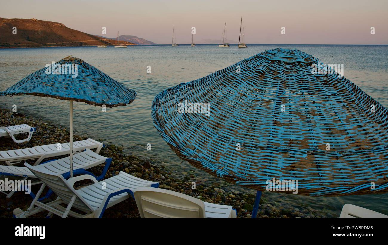 Aegean and Mediterranean coasts at sunset. Wicker umbrellas and sun ...