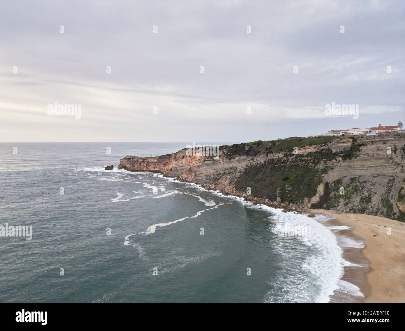 Big Wave Surf Tourism Hot Spot Nazare in Portugal on a cloudy day with ...
