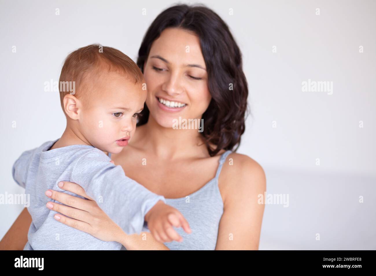 Mom holding toddler in home with smile, bonding and child care with support in morning. Happy ...