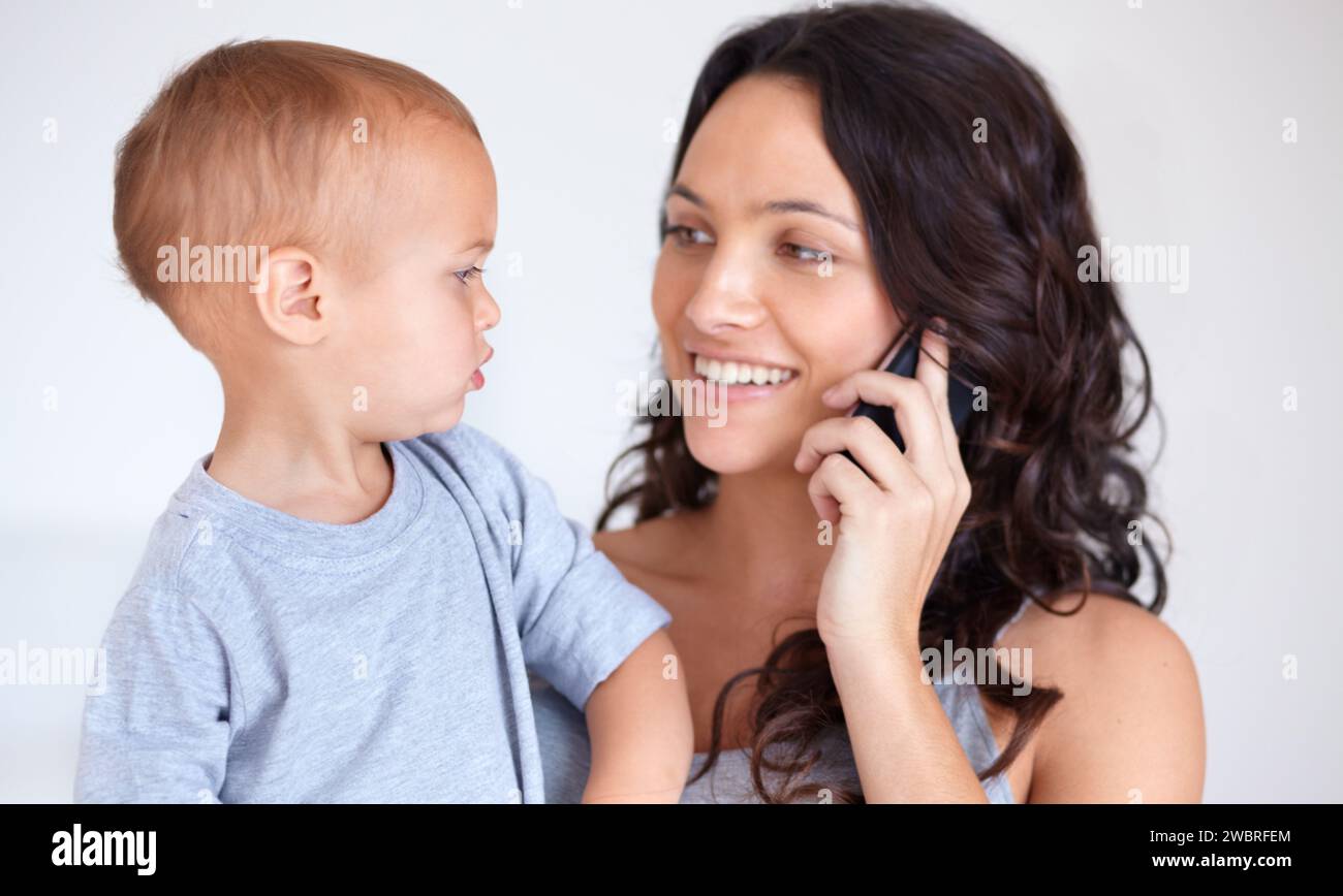 Mom holding toddler in home with phone call, smile and child care with support in morning. Happy ...