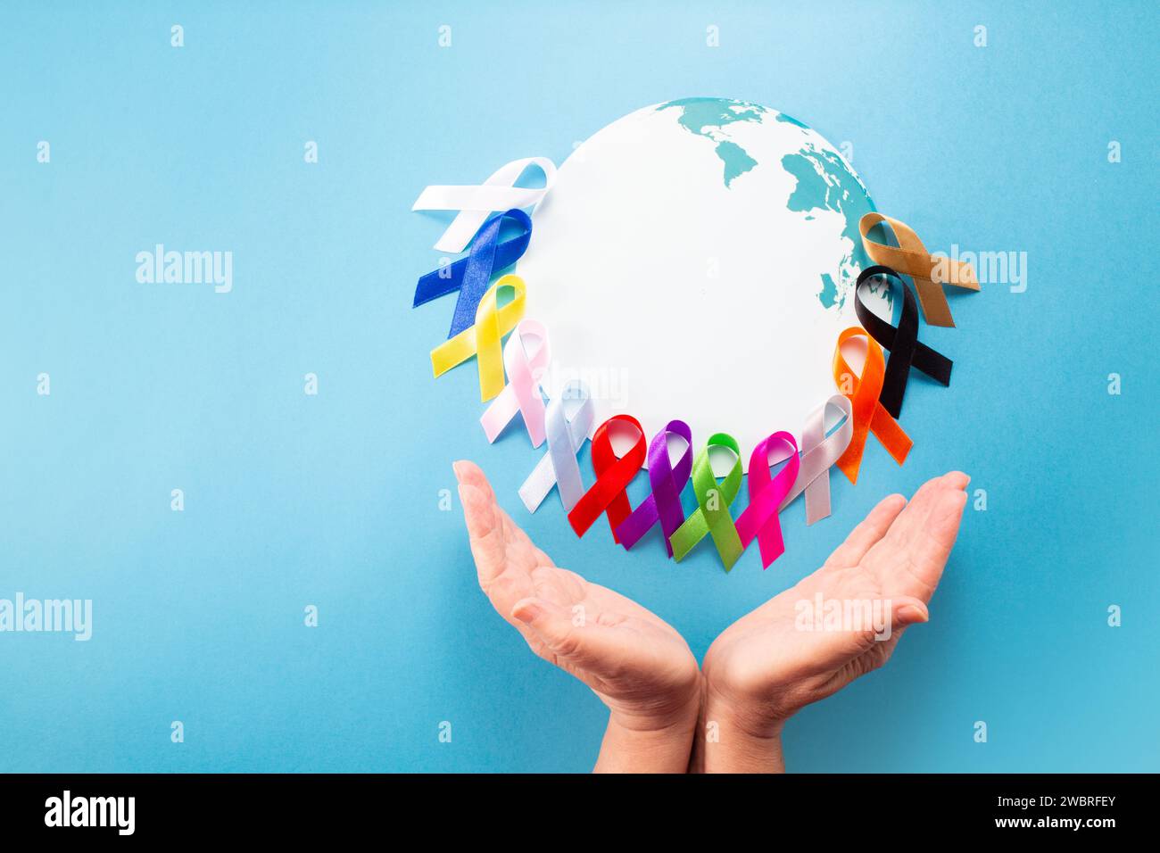 World cancer day February 4. Hand holding colorful awareness ribbons on ...