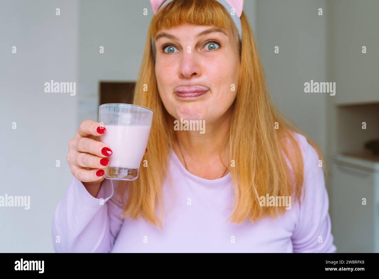 Middle aged woman drinking yogurt Stock Photo - Alamy