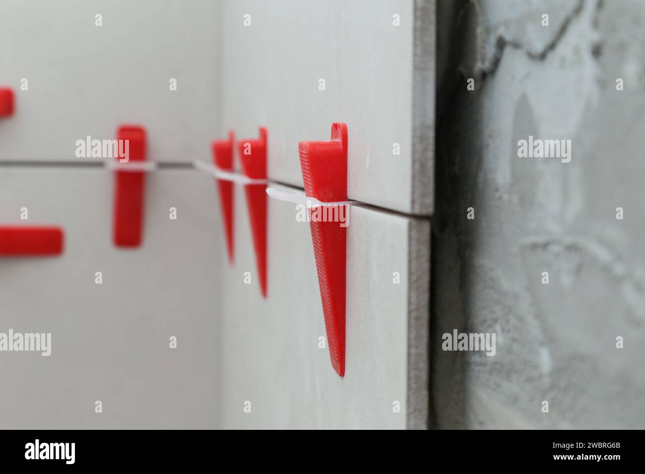 Flat wall plastic tile leveling system. Process of installation of ...