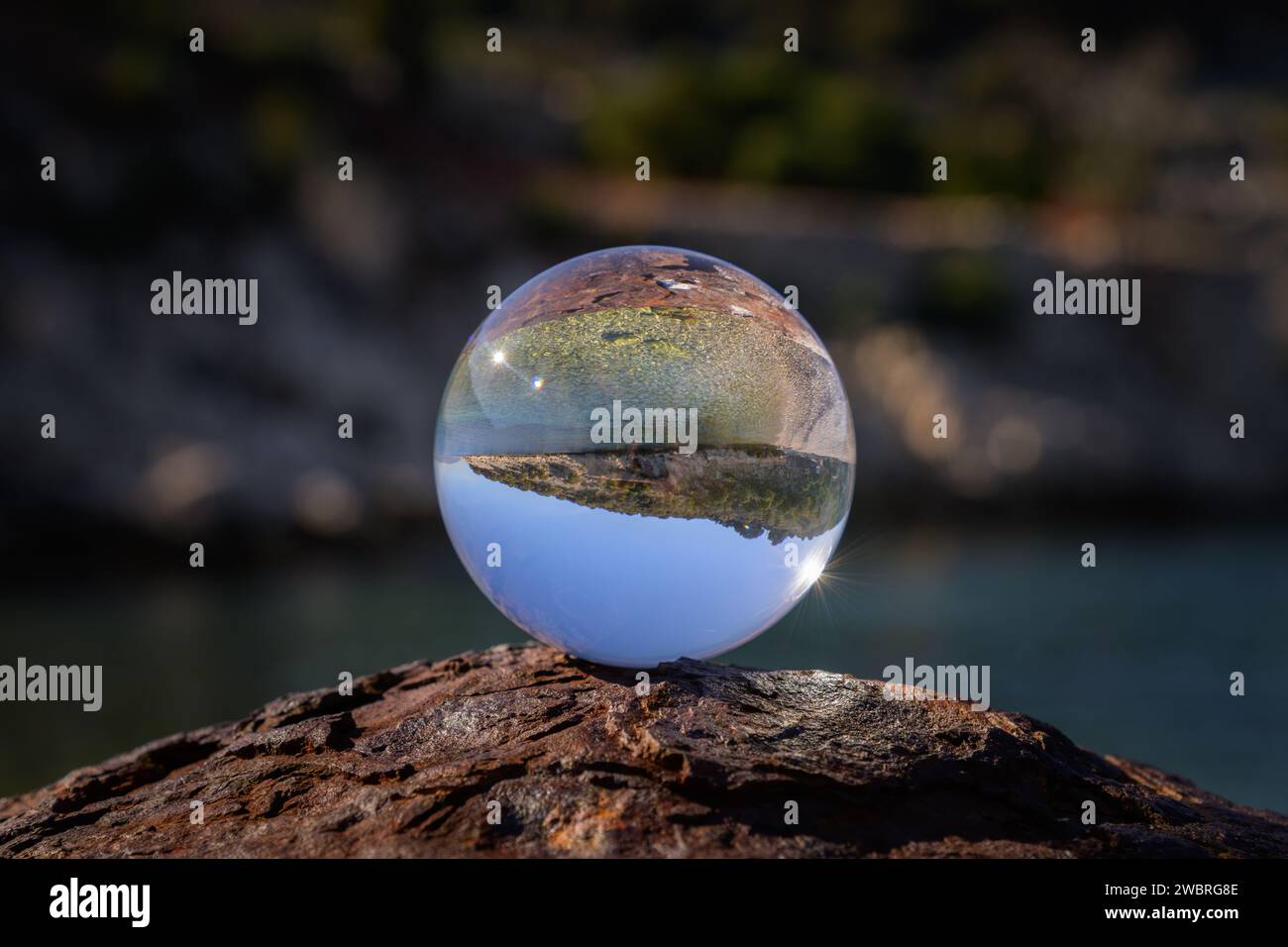 Glass ball lying on a rusty bollard, sunny day in autumn in Cres ...