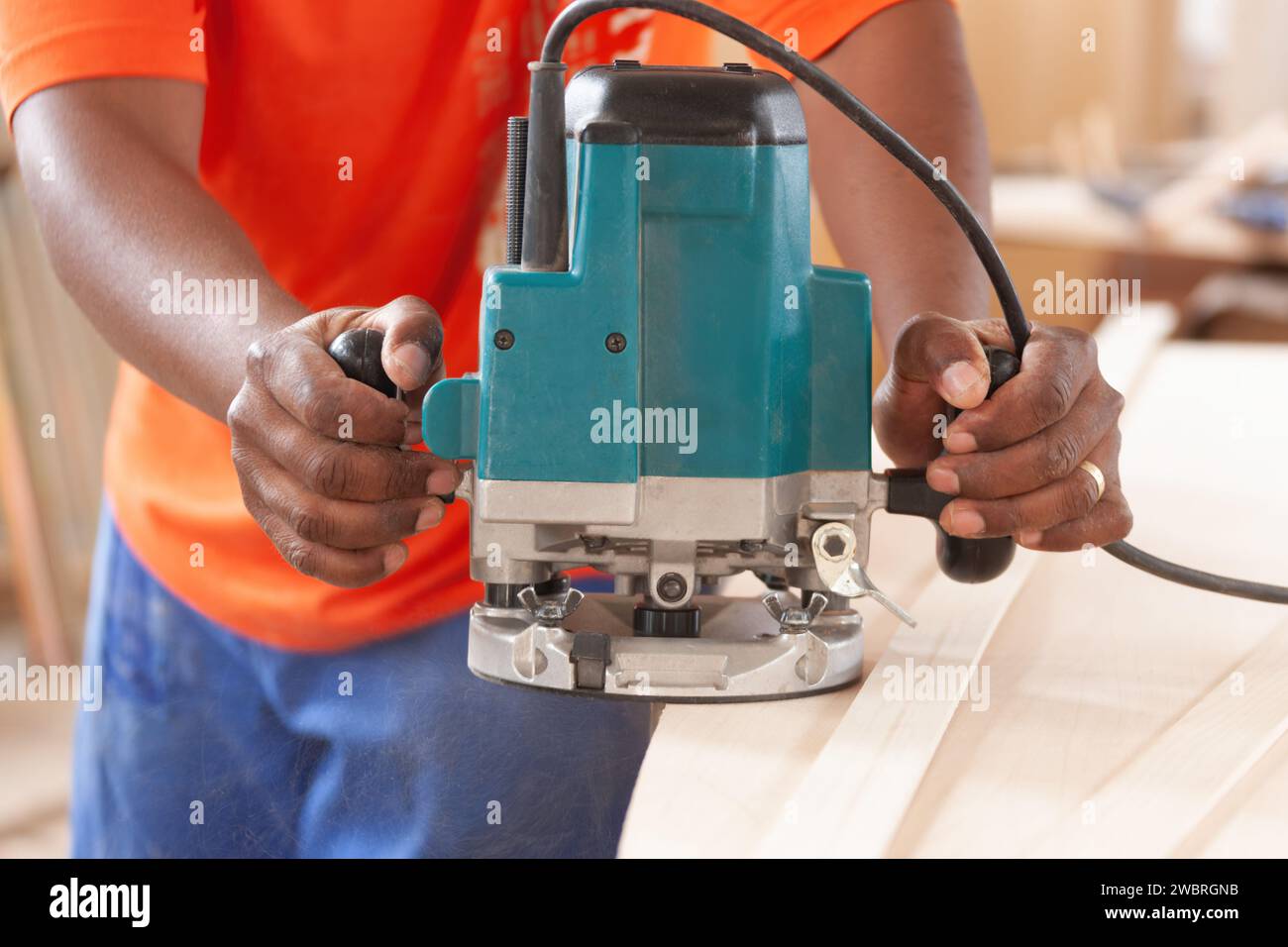 african carpenter using a router to make the edge on a plank Stock ...