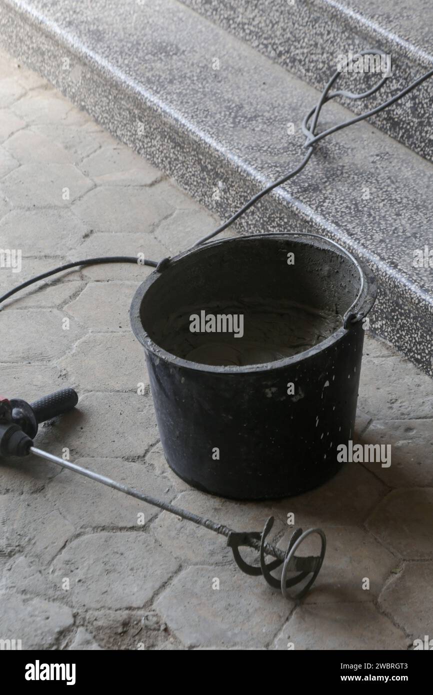 Mortar in bucket and manual mortar mixer on the floor, DIY home ...