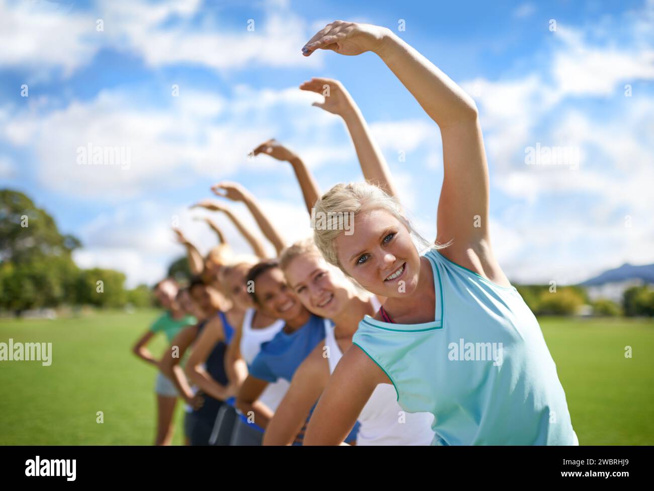 Women stretching, team outdoor and exercise on sports field, fitness ...