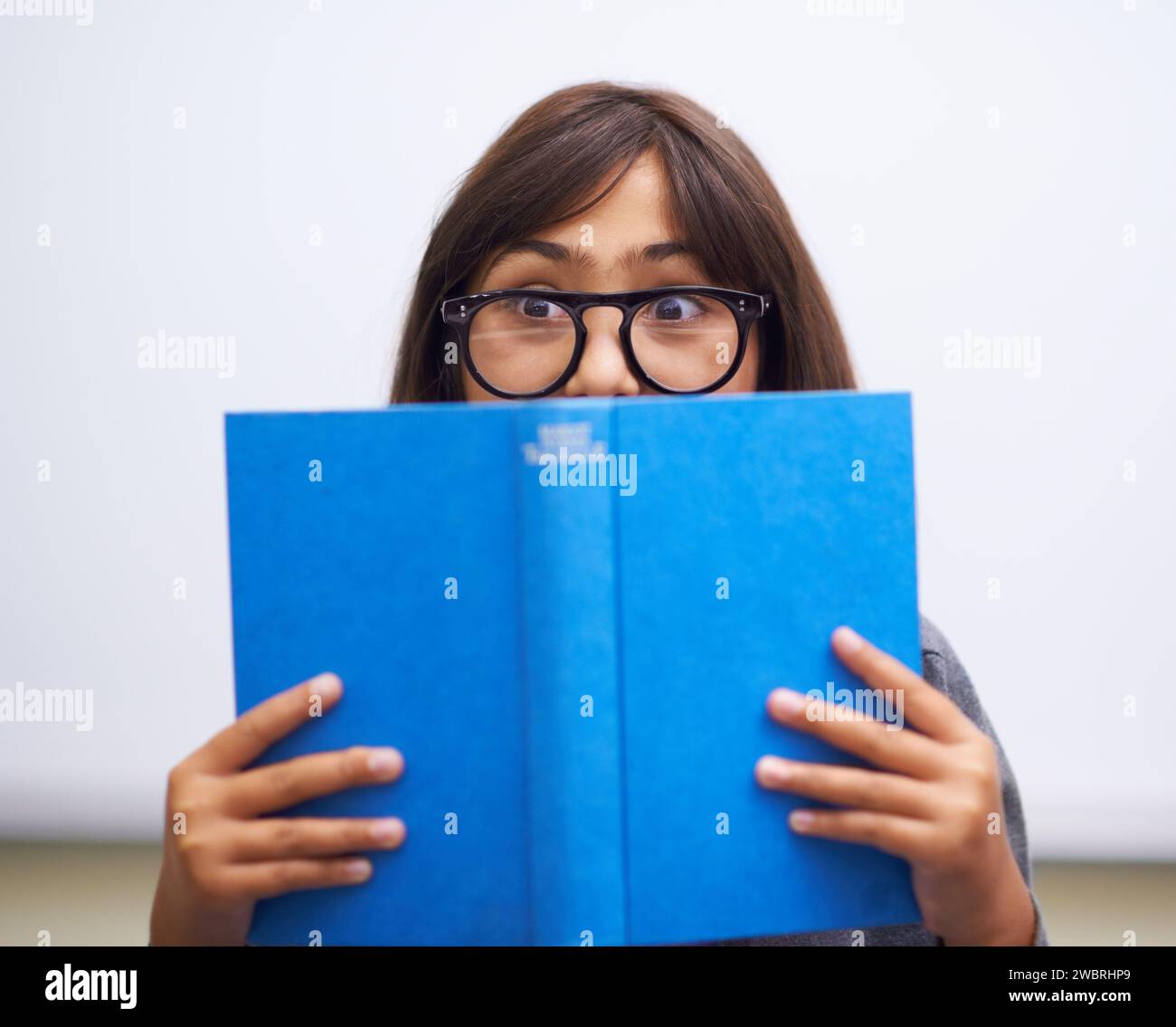 Student, child and hide face with book to read in front for classroom ...