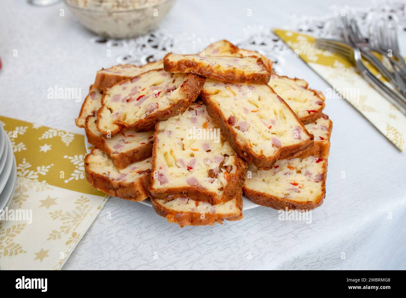 Cake filled with bacon, ham, olives and yellow cheeses sliced on a ...