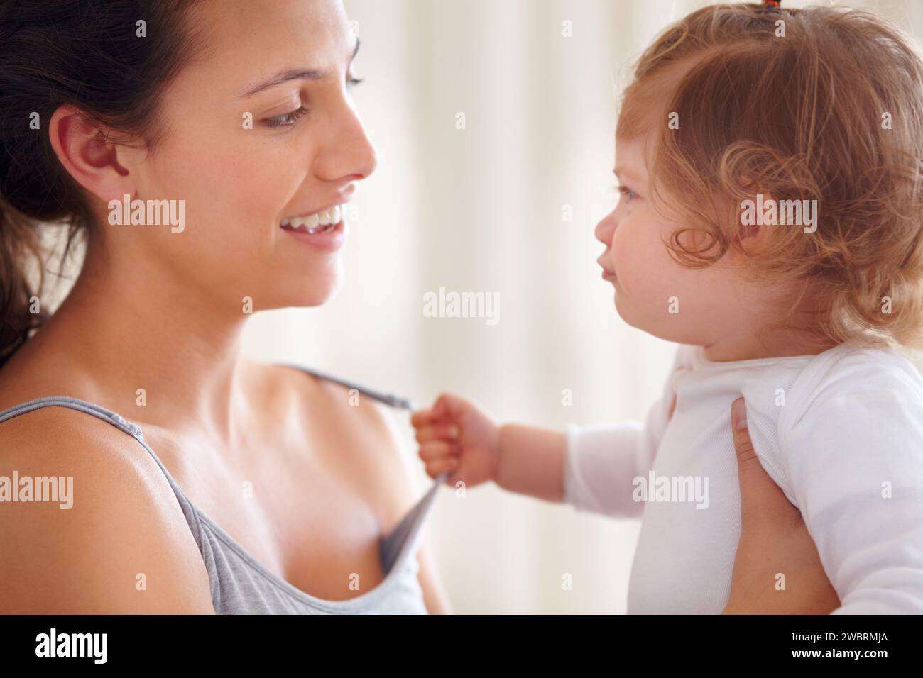 Mom holding baby girl in home with smile, bonding and child care with support in morning. Happy ...