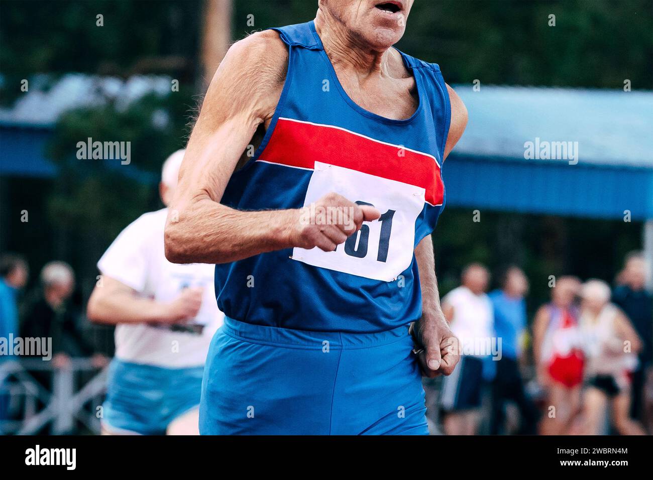 close-up 70-year old male runner running race in masters athletics ...