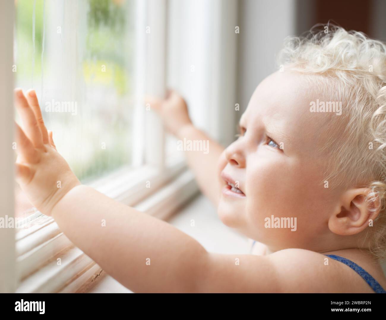 Baby, window and child thinking by glass at home, curious and sad alone ...