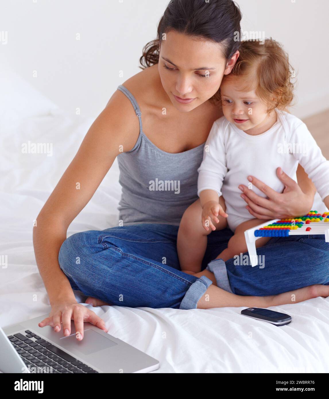 Laptop, baby and mother in bedroom for remote work, learning or online ...