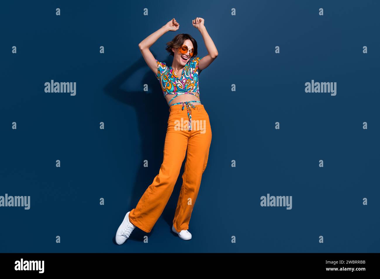 Full size photo of attractive young woman raise hands dancing promotion ...