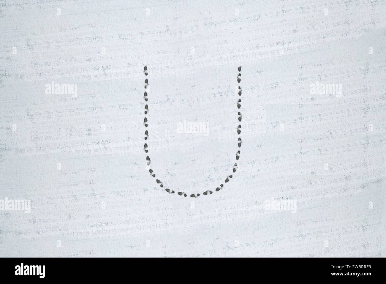 The letter U written in the snow. Winter writings Stock Photo - Alamy