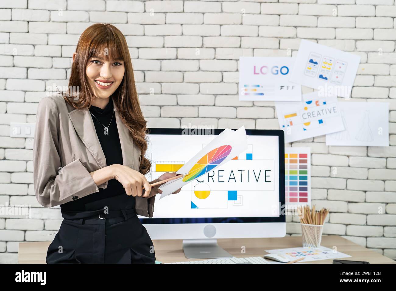 A young Asian graphic designer woman working in a creative dynamic ...