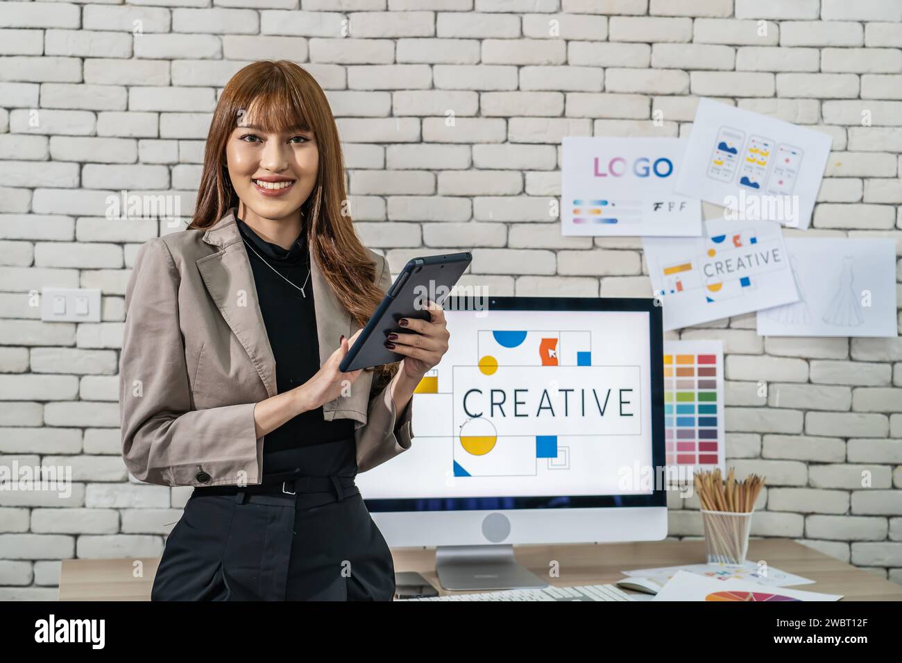 A young Asian graphic designer woman working in a creative dynamic ...