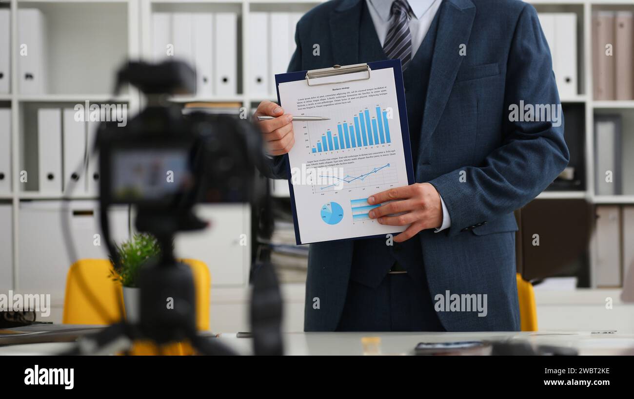 Male in suit and tie show stats graph pad Stock Photo - Alamy