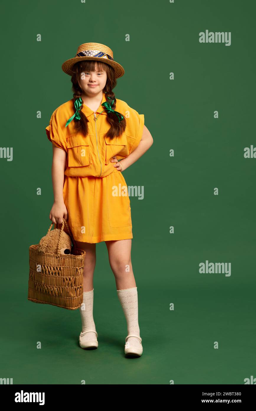Beautiful teen girl with down syndrome wearing yellow dress and hat ...