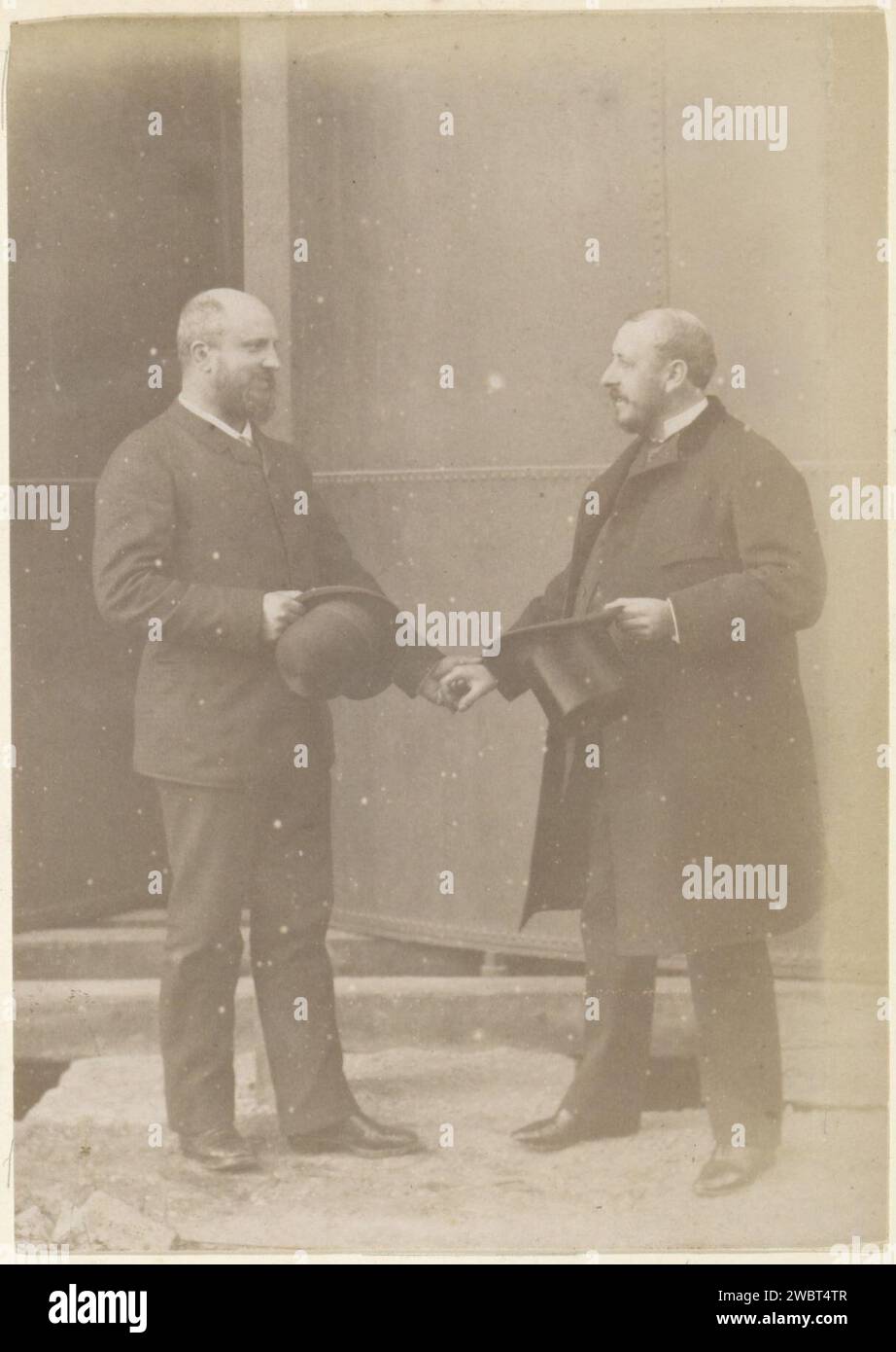 Portrait of two French men with hats, hand in hand standing in front of ...