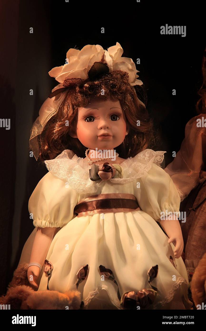A pretty doll with a nice vintage dress and flowers in her hair Stock Photo - Alamy