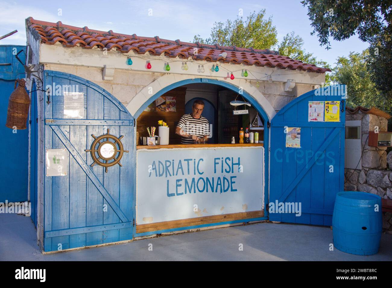Small beach bar (kiosk) with Adriatic fish lemonade. bartender behind ...