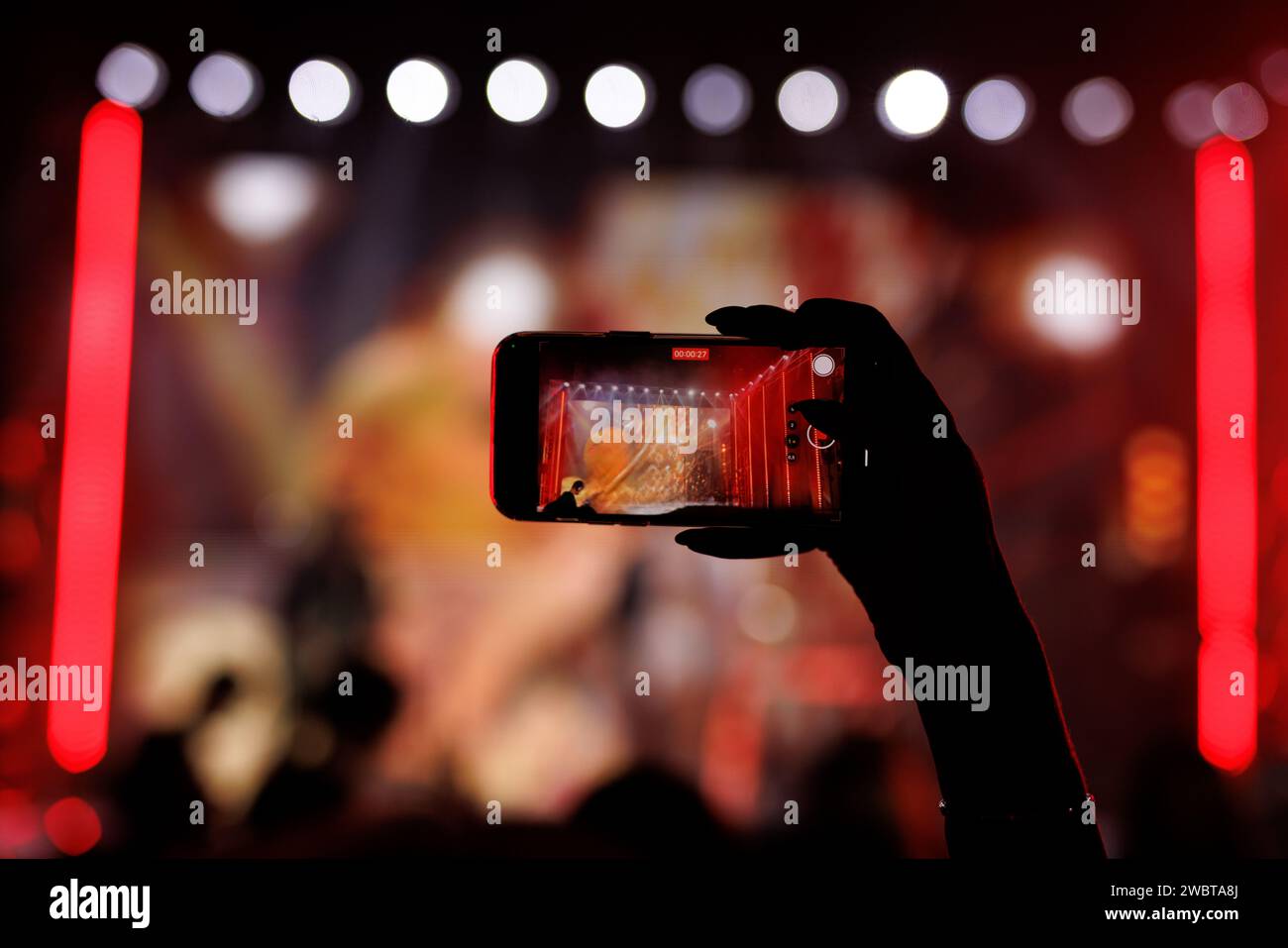 Hand holding a smartphone for filming a concert Stock Photo - Alamy