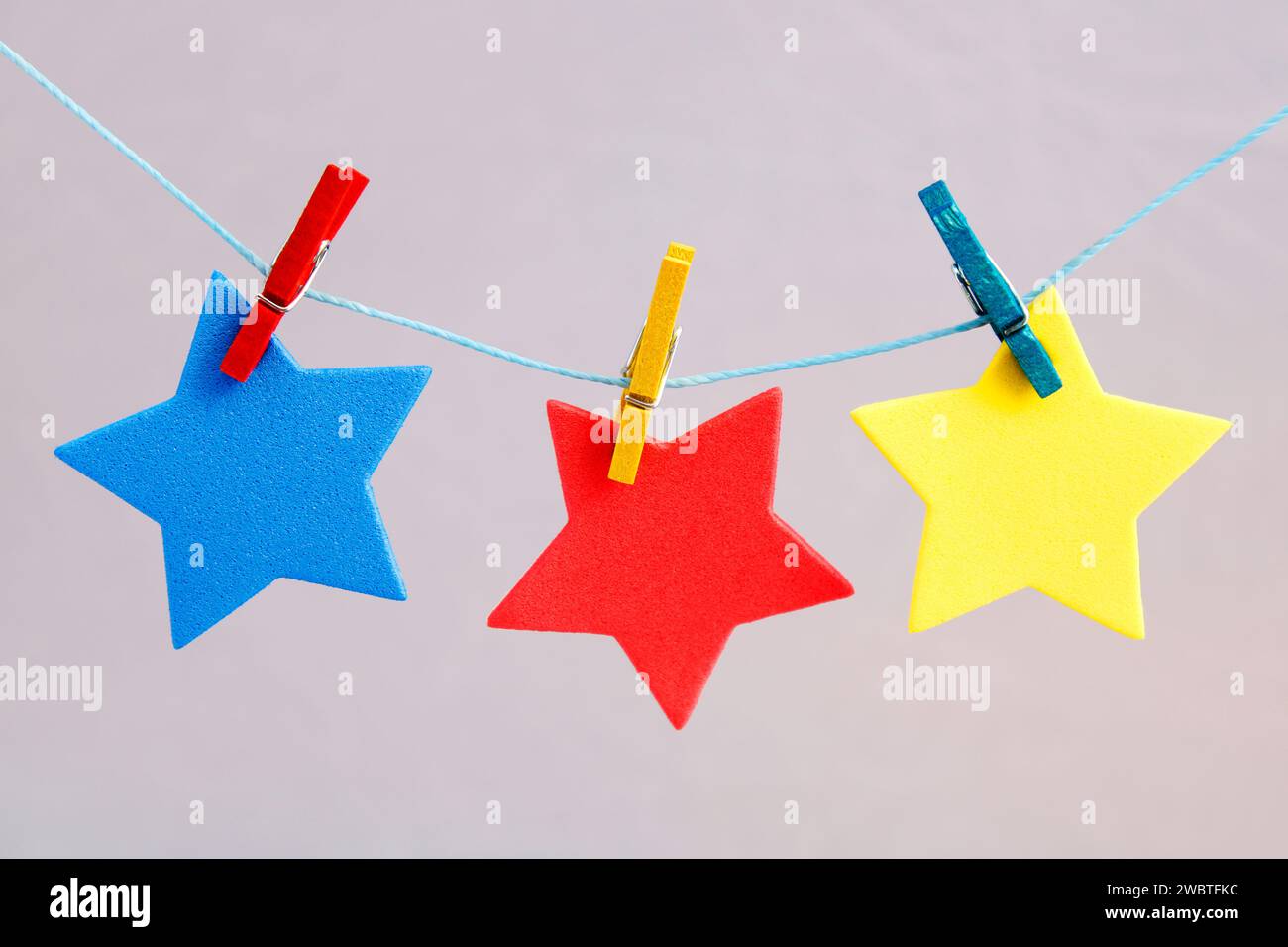 Colored stars attached to rope with clothespins Stock Photo - Alamy