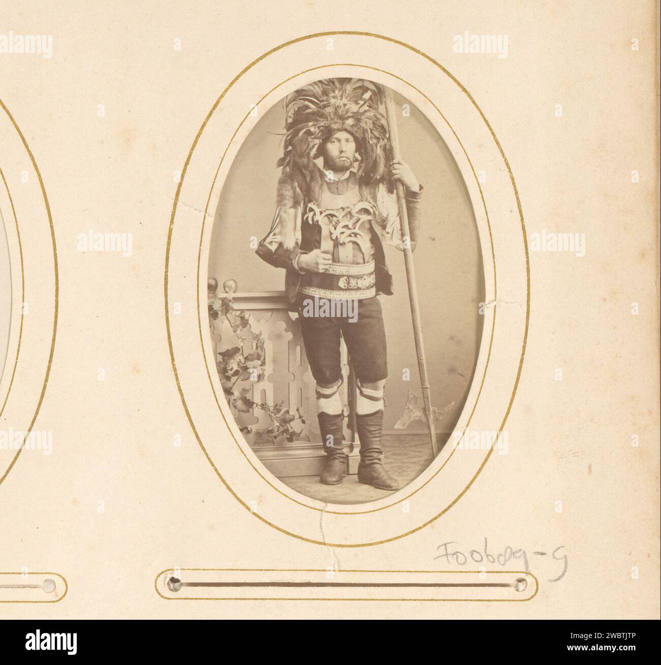 Portrait of a standing man in a historic costume with a fee and ...