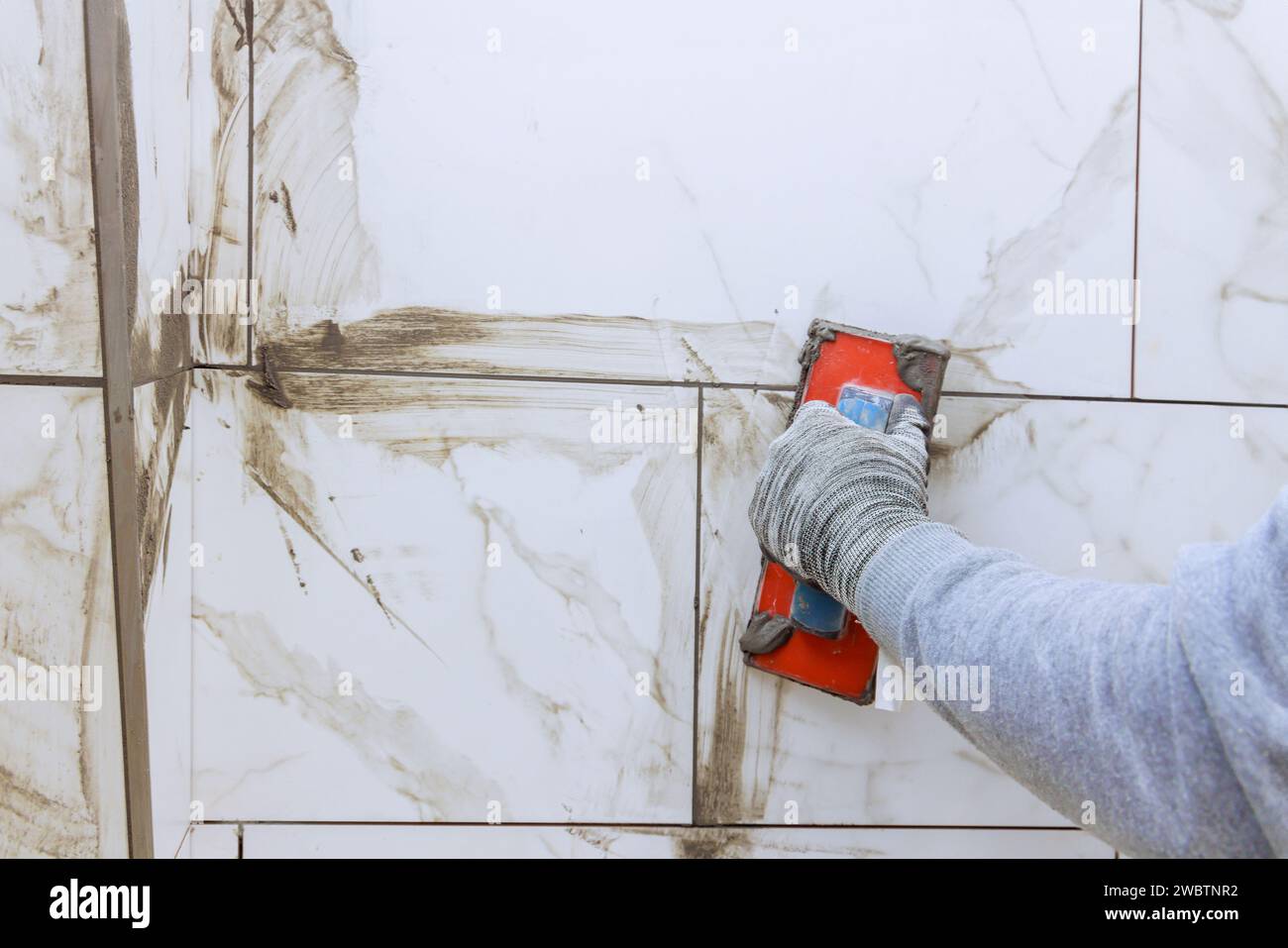 Tilers Filling Gaps Between Ceramic Tiles With Rubber Trowel When