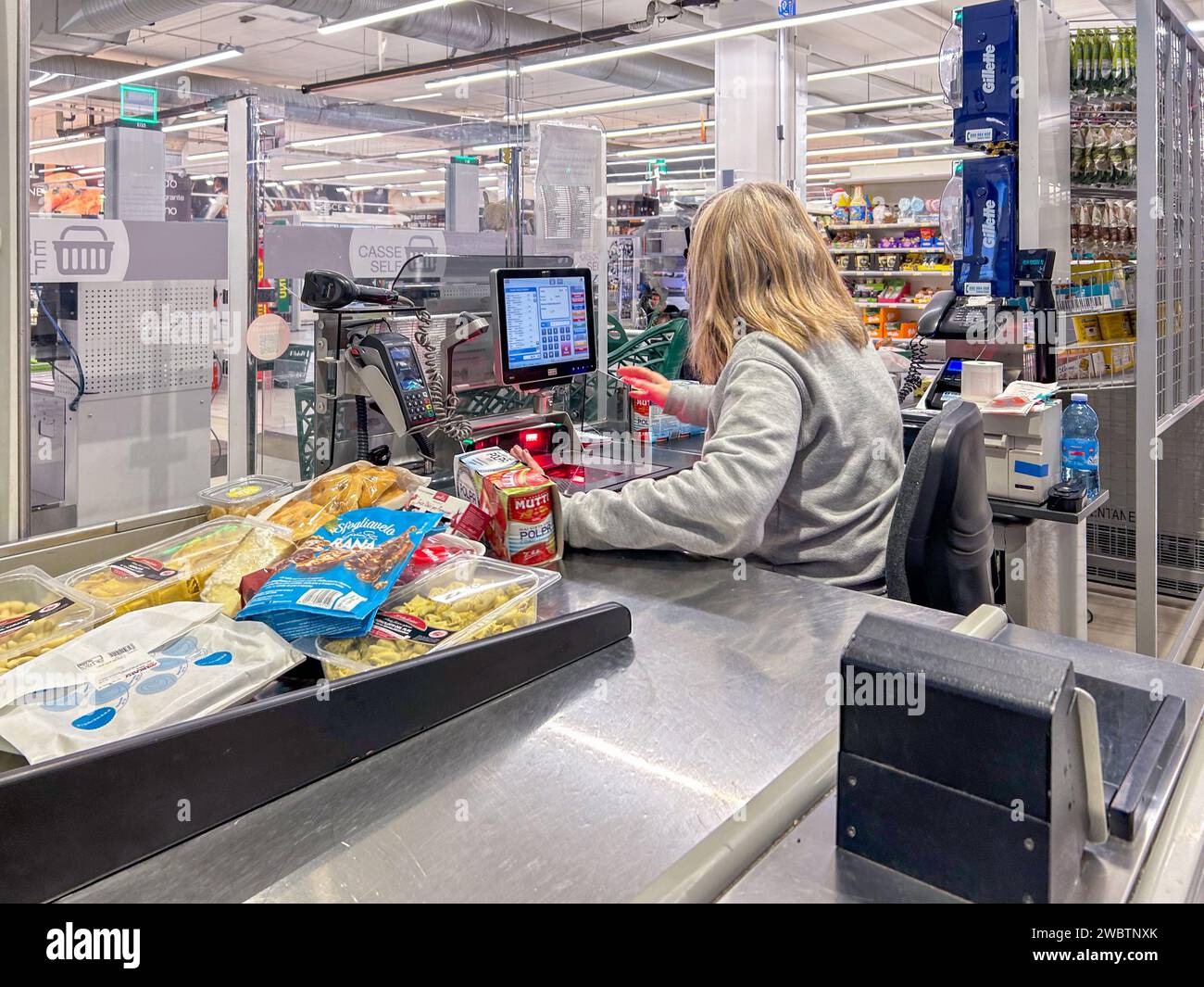 italy - January 12, 2024: Supermarket checkout with cashier passing ...