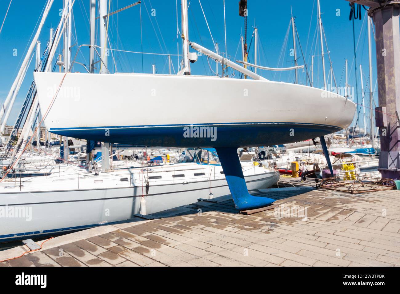 Boat (sailboat) under maintenance with centerboard. White and blue boat ...