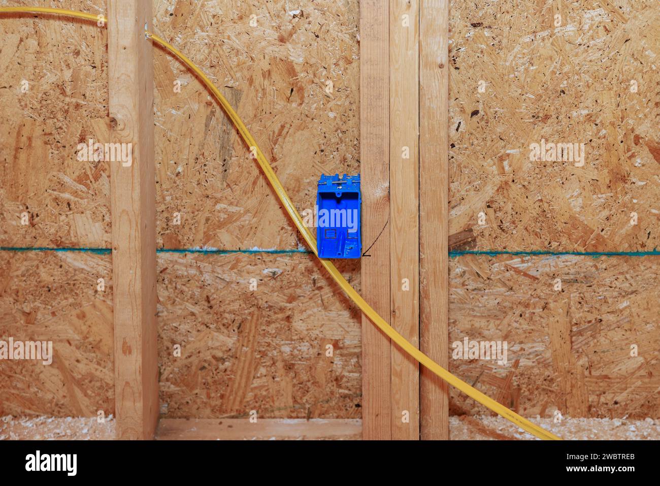 An electrical switch box made of plastic with wires attached to wooden ...