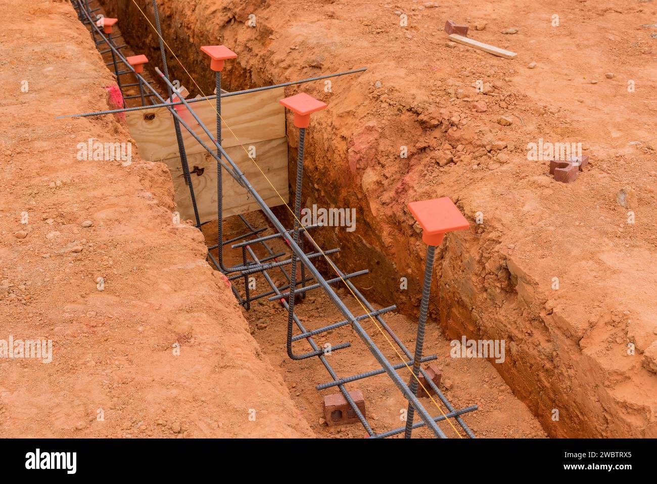 Concrete foundations are being poured into trenches dug during trench ...