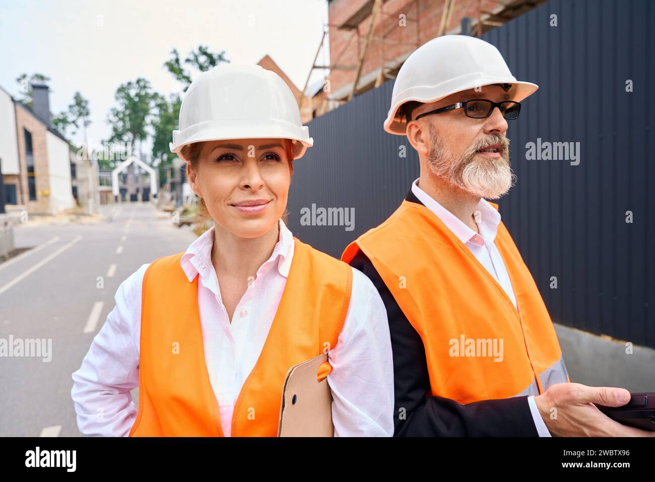 Construction staff in hard hats inspecting development site Stock Photo ...